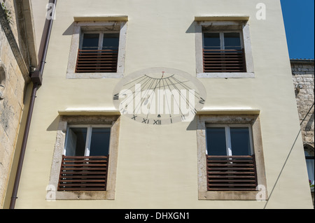 House wall with sundial and four windows Stock Photo - Alamy