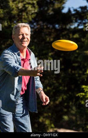 Young man playing frisbee on green grass Stock Photo - Alamy