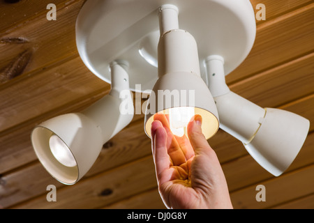 The man changes the lamp. Energy-saving lamp. Replacement of an energy ...