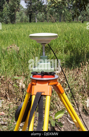 Land surveyor working with a GPS instrument, checking data online with ...
