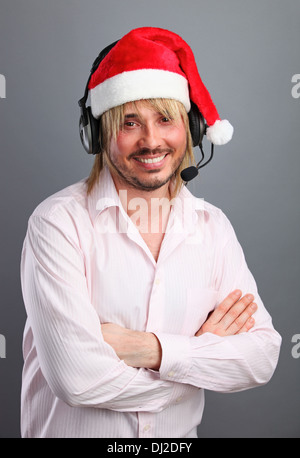 Young caucasian man wearing christmas hat showing smartphone screen ...