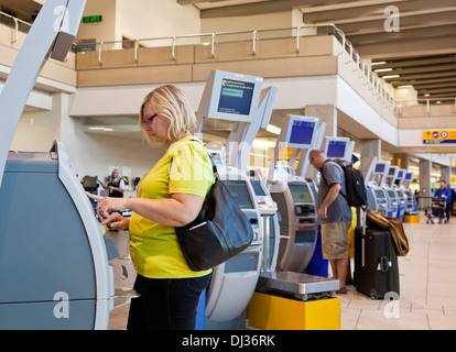 Calgary woman using automatic check in machines airport departures hall ...
