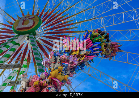 A photograph of a tower of balloons in front of a ferris wheel at the ...