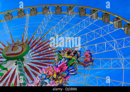 A photograph of a tower of balloons in front of a ferris wheel at the ...