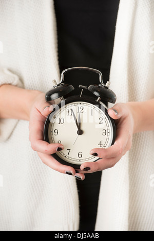 Female hands with alarm clock in bedroom, closeup. Daylight saving time ...
