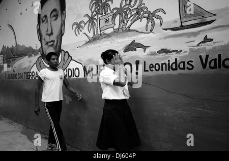 Schoolgirls from the Guna people walk past a painted wall depicting ...