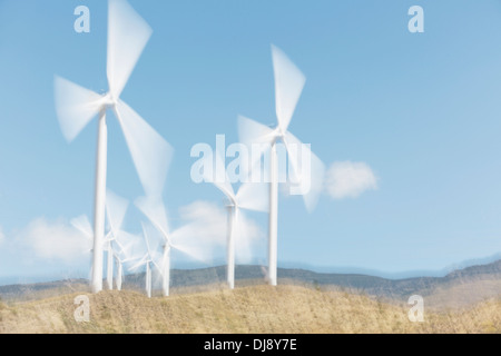 Windmill wind turbines spinning fast in wind at sunset or sunrise Stock ...