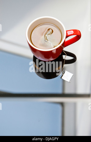 Tea steeping in mug on glass table Stock Photo - Alamy