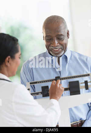Doctor and patient adjusting scale Stock Photo - Alamy
