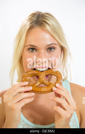Woman biting into a pretzel Stock Photo - Alamy