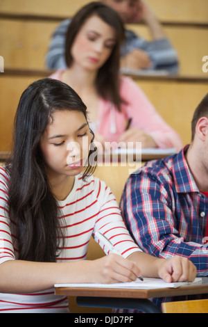 Focused asian student taking notes in class Stock Photo - Alamy