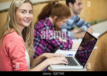 Portrait of a happy students using laptop computer together in ...