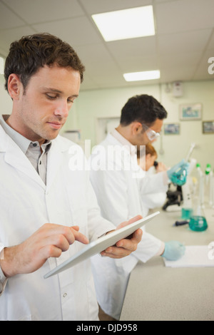 Serious scientist using tablet pc Stock Photo - Alamy