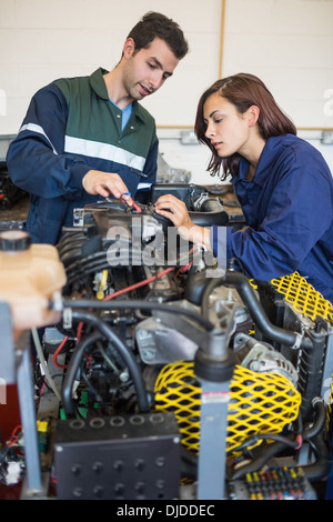 Calm trainee and instructor repairing an engine Stock Photo - Alamy