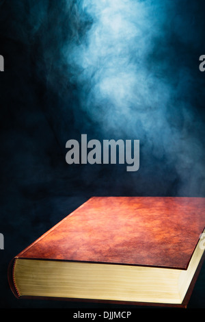 Floating unopened book and smoke, dark background Stock Photo - Alamy
