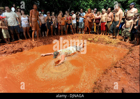 A competitor in the Summer Redneck Games takes a belly flop into a mud ...