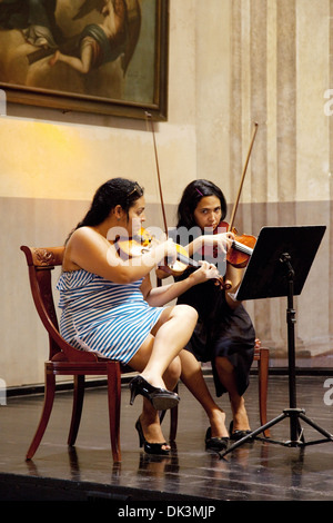 Two women musicians playing classical guitar using laptp at music ...