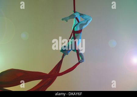 Aerial dancer with red ribbon upside down Stock Photo - Alamy