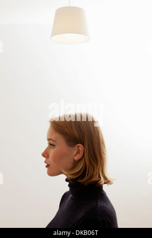 Young woman standing over blue background pointing aside worried and ...