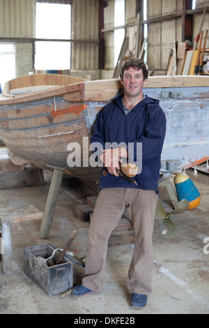 Portrait of male worker repairing boat engine in docks, copy space ...