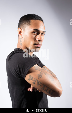 Young tattooed adult man showing and pointing up with fingers number ...