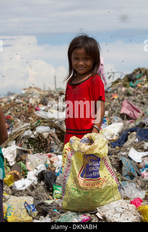 A child surrounded by flies,scavenging for anything of value within the ...