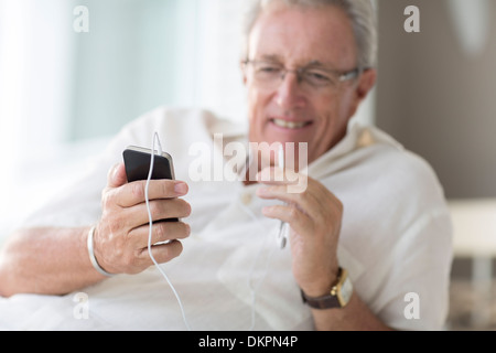 Older man using cell phone on sofa Stock Photo - Alamy