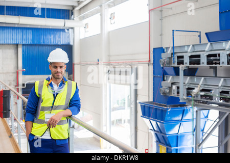 Worker smiling in factory Stock Photo - Alamy