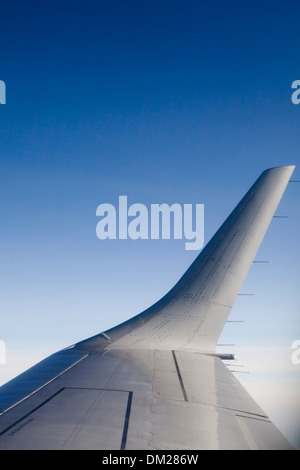 Flying over the clouds. Airplane wing with blue sky and copy space ...