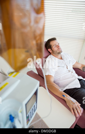 Cancer chemotherapy. Male patient receiving anticancer drugs from an ...