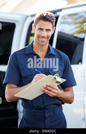 Portrait of delivery man in uniform holding parcel box isolated over ...