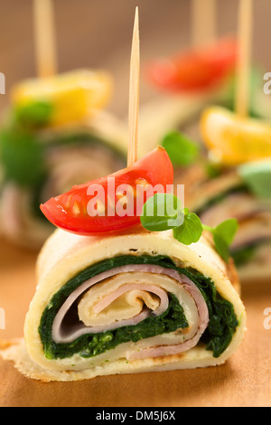 Crepe rolls as finger food filled with spinach and ham garnished with ...