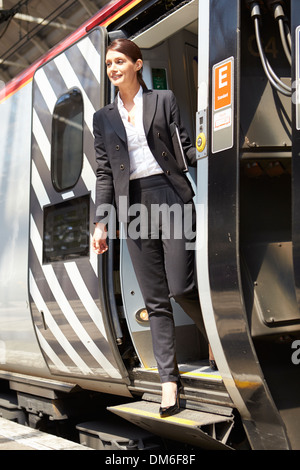 Woman Getting Off a Train at a Railway Station Stock Photo - Alamy