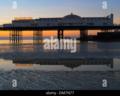 Brighton Pier sunset at low tide, with the West Pier through the arch ...