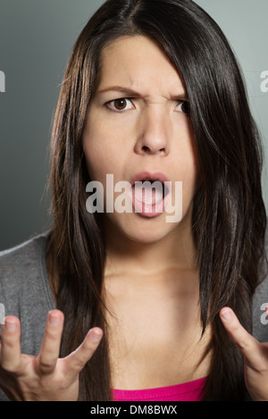 Aghast attractive young woman with a horrified expression looking at a ...