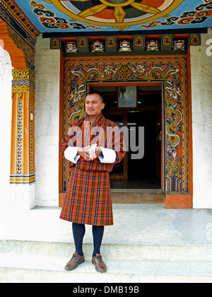 A Bhutanese man wearing the traditional Gho walks across a suspension ...