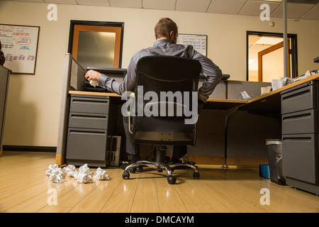 Office worker working late, throwing paper in the air Stock Photo - Alamy
