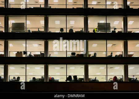 Office block with an all glass frontage showing people at their desks ...