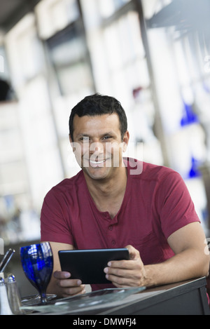 Middle age hispanic man using laptop sitting on the floor at the living ...