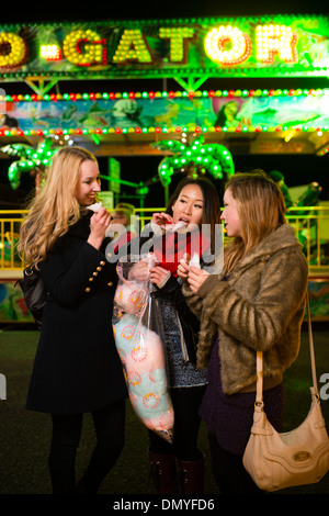 Fun Fair UK; Three girls enjoy a ride at the fairground funfair ...