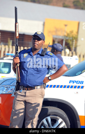 A South African JMPD police officer in riot gear holding police tape ...