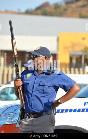 A South African JMPD police officer in riot gear holding police tape ...