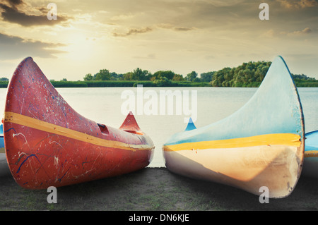 Canoes on the shore of the lake at sunset Stock Photo - Alamy