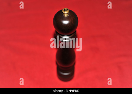 A large pepper grinder photographed against a red background Stock ...