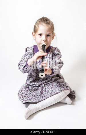 Cute little girl playing flute in classroom Stock Photo - Alamy