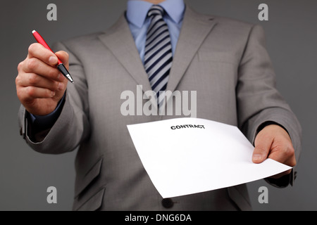 Businessman signing contract or application form leaning on his office ...