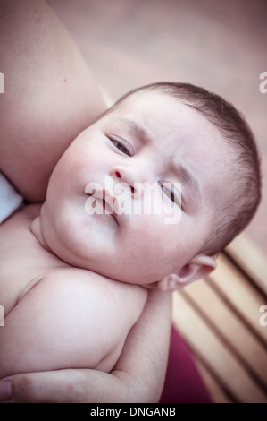 Hand, new born baby curled up sleeping on a blanket, multiple ...