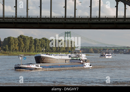 Germany, Cologne, cargo ships on the river Rhine, view to the old tower ...