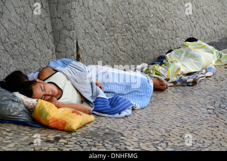 Rio de Janeiro, Brazil. Homeless street child crouching in the gutter ...