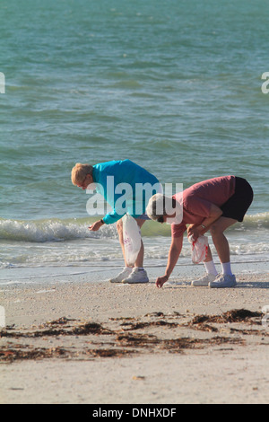 You can see visitors doing the "Sanibel Stoop" on the island's shores ...